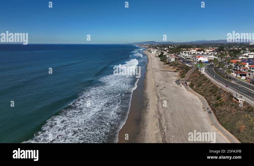 Aerial drone shot over the sandy beaches of Carlsbad. Town on one side ...
