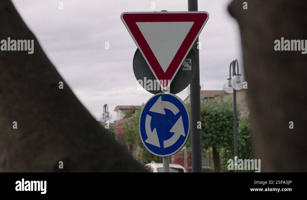 Close up of road signs through a gap in the trees. Static view. Italy ...