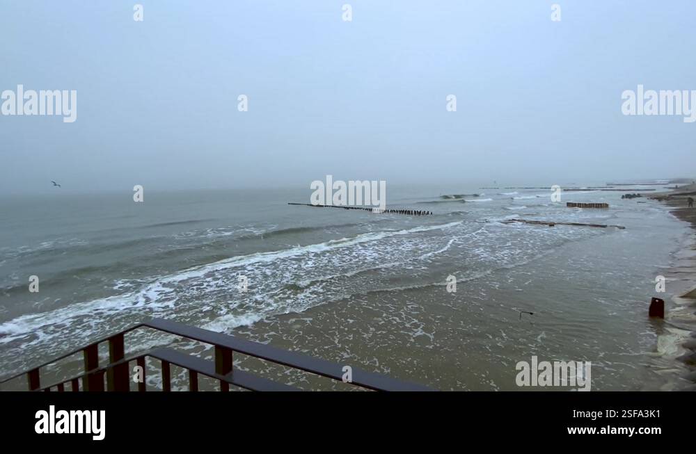 Panning of sea and cloudy and cold beach in winter on city of Mielno ...
