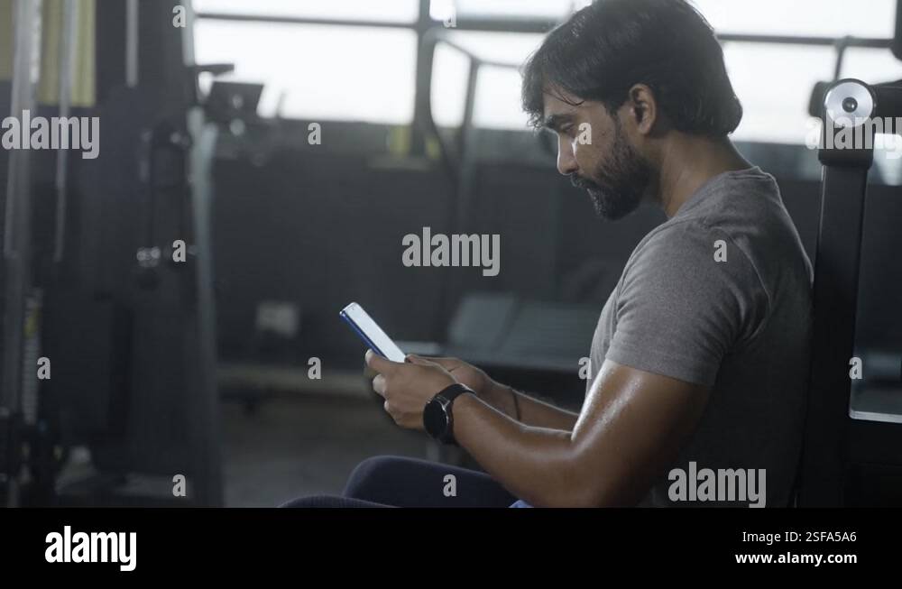 happy smiling sweat athlete busy using mobile phone after intense ...