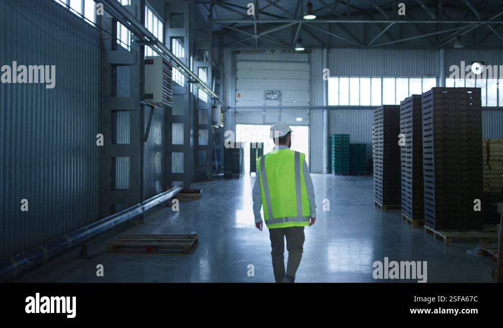 Storehouse employee back view walking at factory storage workplace ...