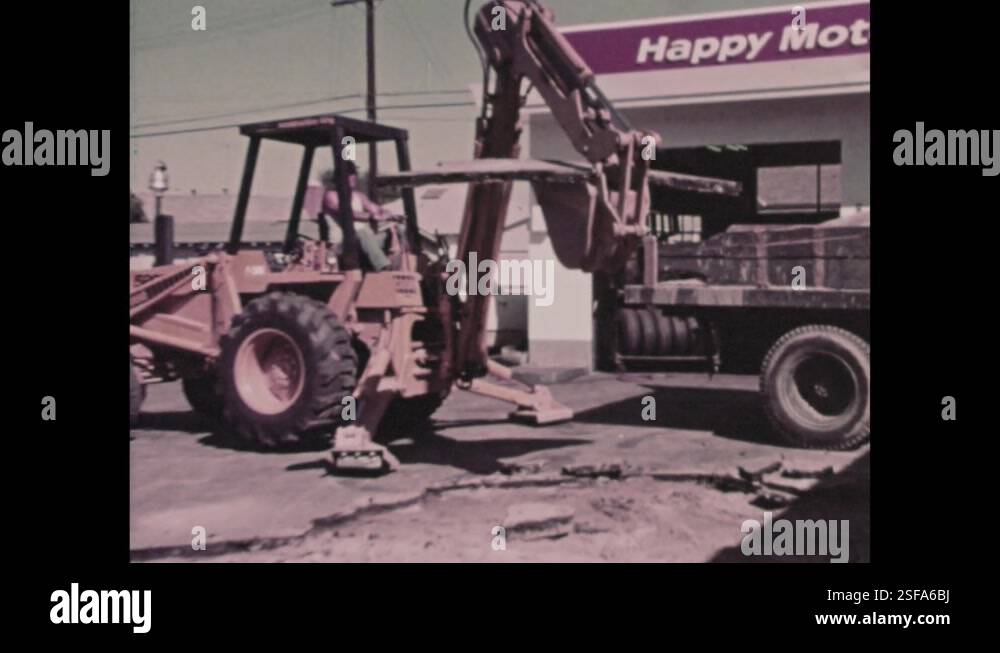 1970s: Man stands looking at blueprints on display for presentation ...