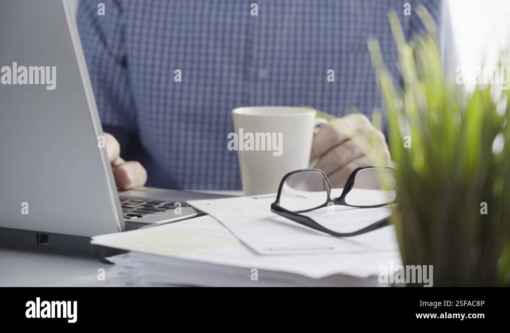 The Man Drinks a Coffee, Pausing to Work with Documents at the Office ...