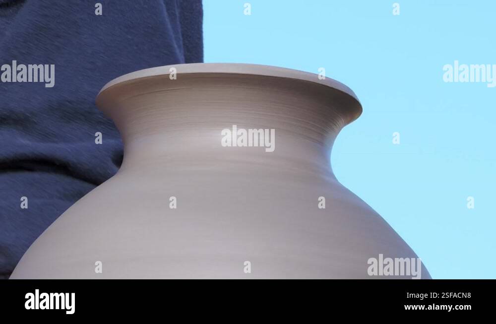 Potter inserts arm into clay vase to shape it | close-up static shot ...