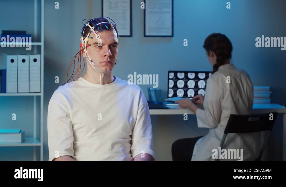 Man wearing EEG topographer for examining brain, doctor making ...