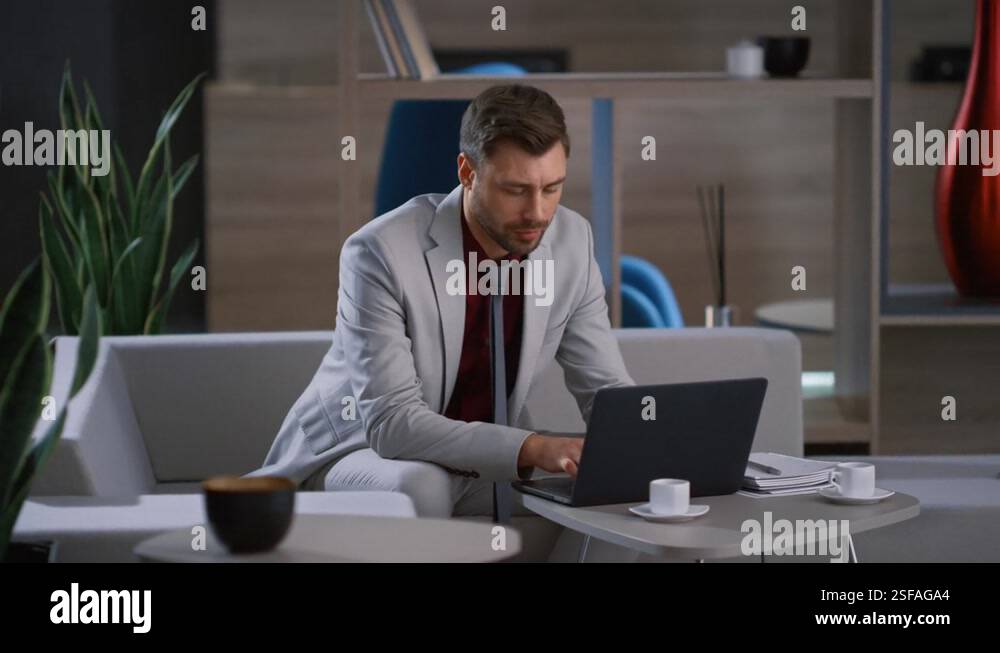 Young businessman working laptop computer waiting colleague in remote ...