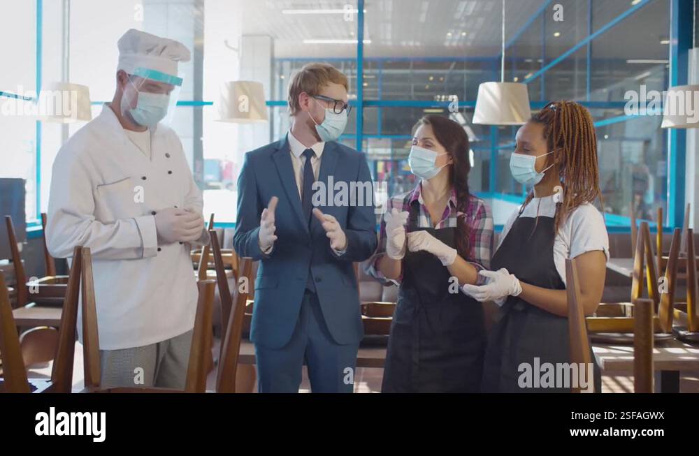 Manager in safety mask having briefing with restaurant team before ...