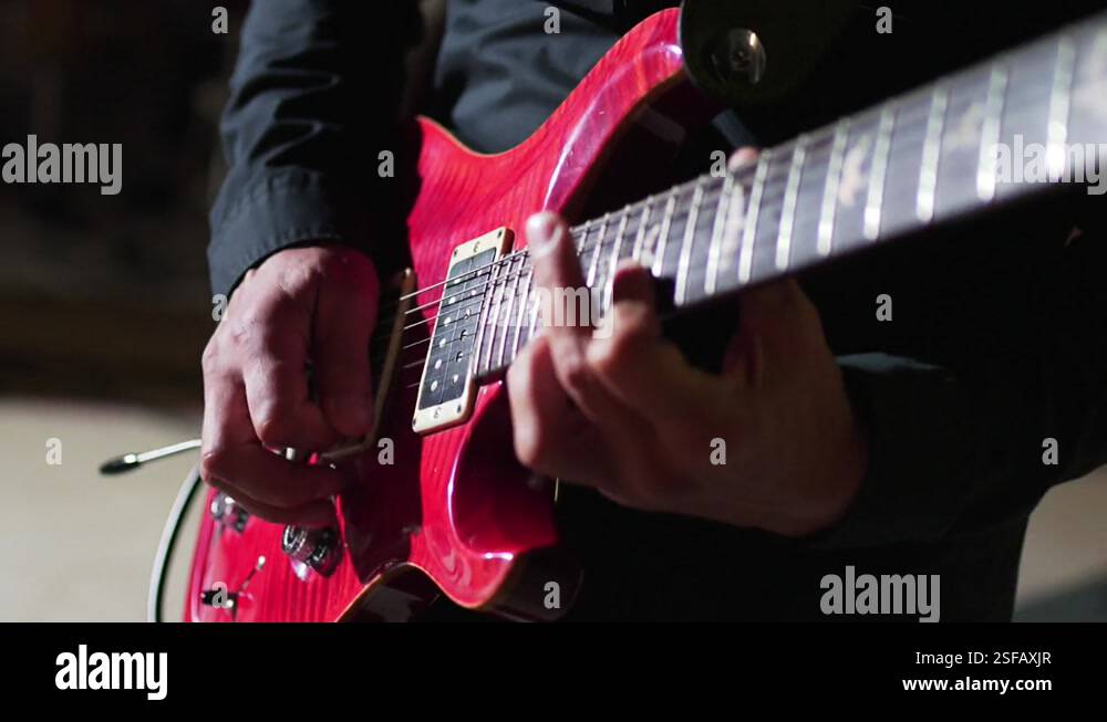 The guitarist plays an instrument. Red guitar at the performance, close ...
