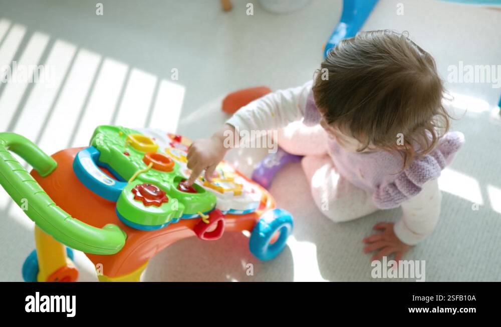 Two years old baby girl study to press buttons on interactive board of ...