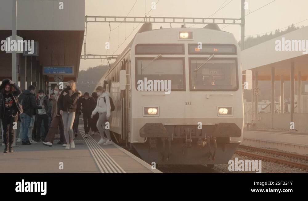 Train passengers getting off train stopped at outdoor station in Stock ...