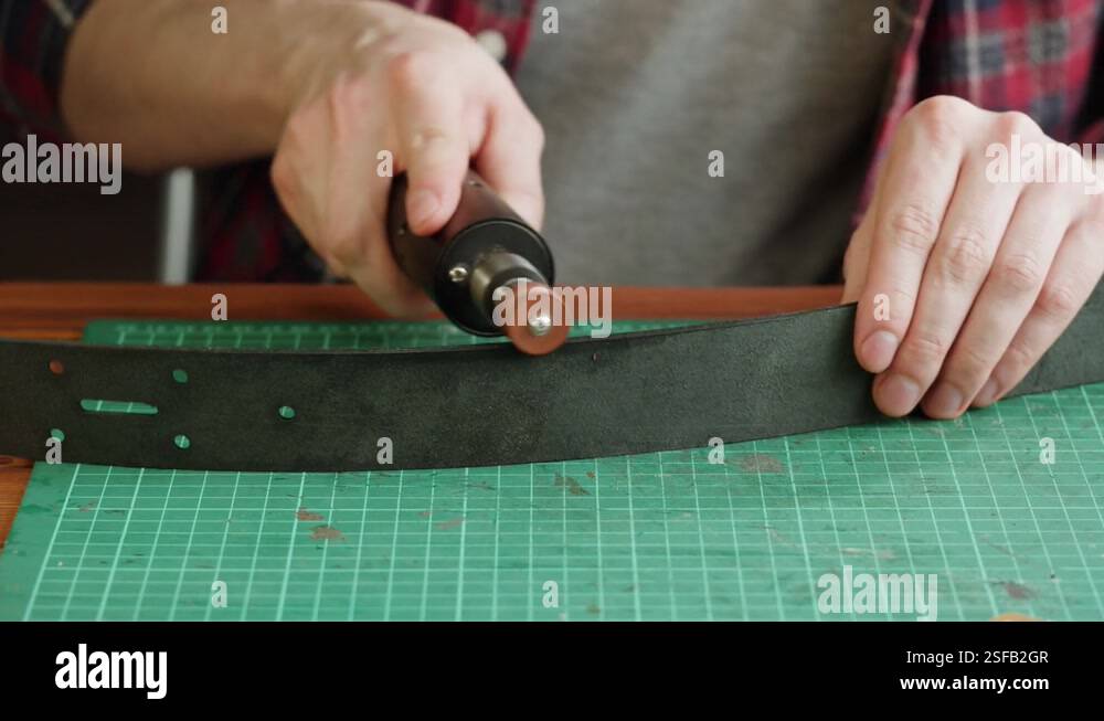 Man tailor polishing artificial leather close-up. Craftsman buffing ...