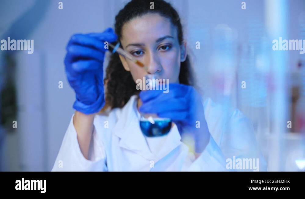Chemical laboratory researcher mixing fluids in test tubes, studying ...