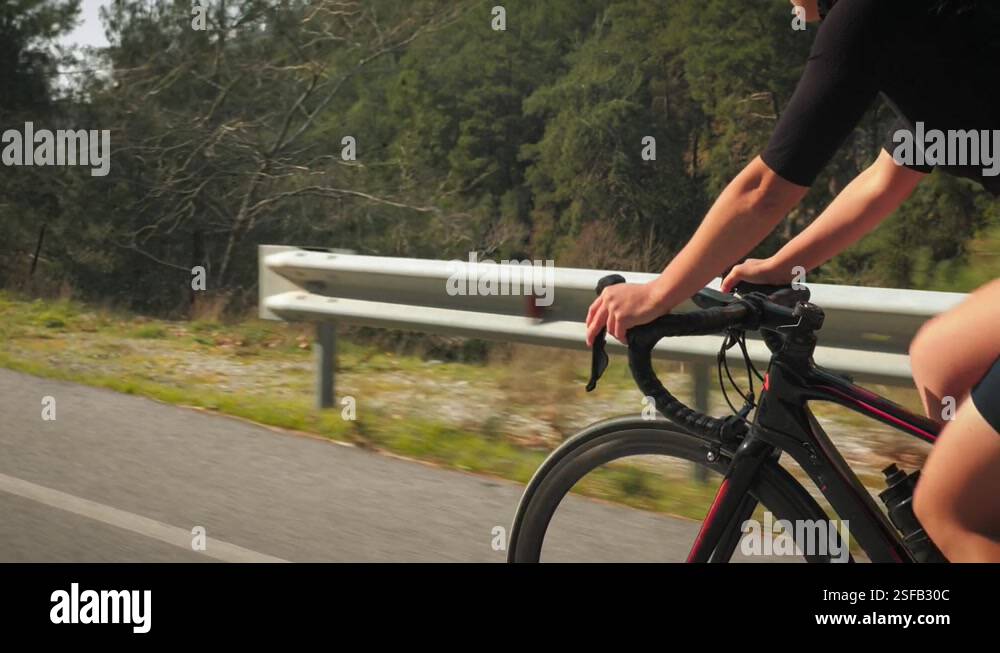 Cycling on road bike outside. Bike wheel rotation. Woman cyclist riding ...