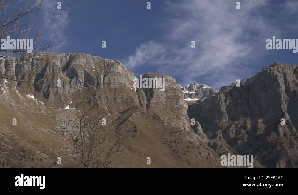 pan of mountain range on crisp clear cold winter day with blue sky and ...