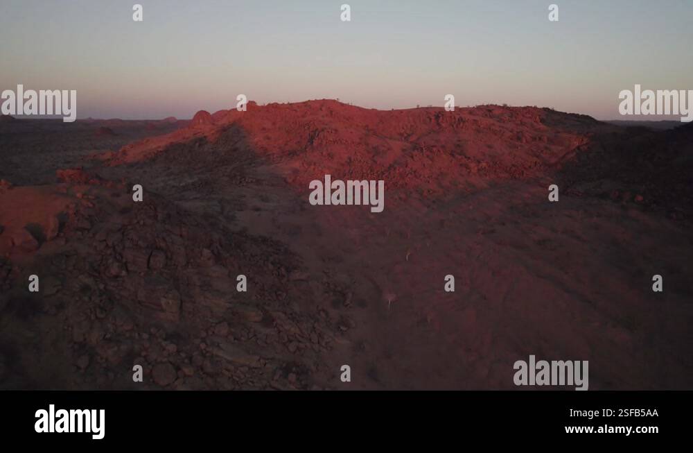 Arid African desert landscape glows red at sunset, Namibia; aerial ...