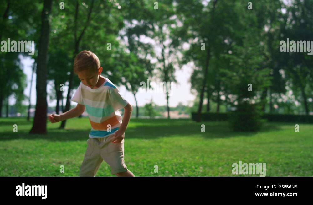 Little boy training before soccer match. Kid warming up alone in sunny ...