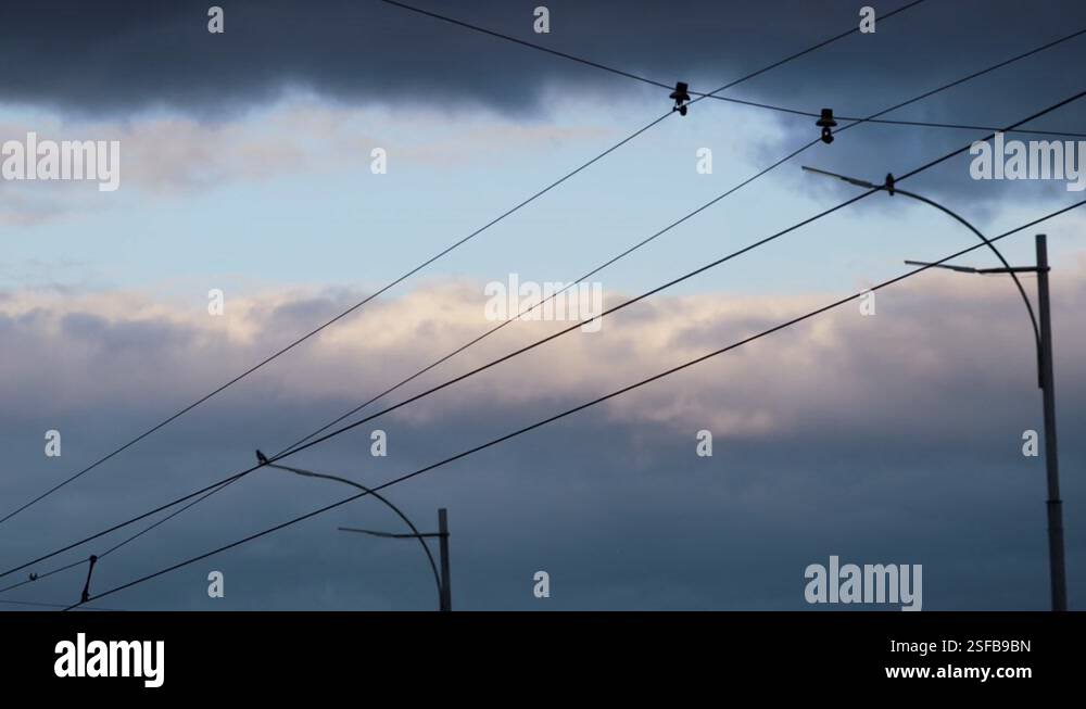 Electrical wires at cloudy sky. Not working city street lamp posts ...