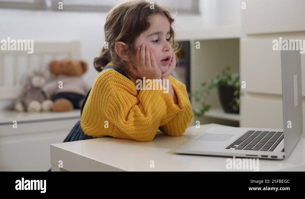 Little overwhelmed girl looking at computer screen in an online class ...