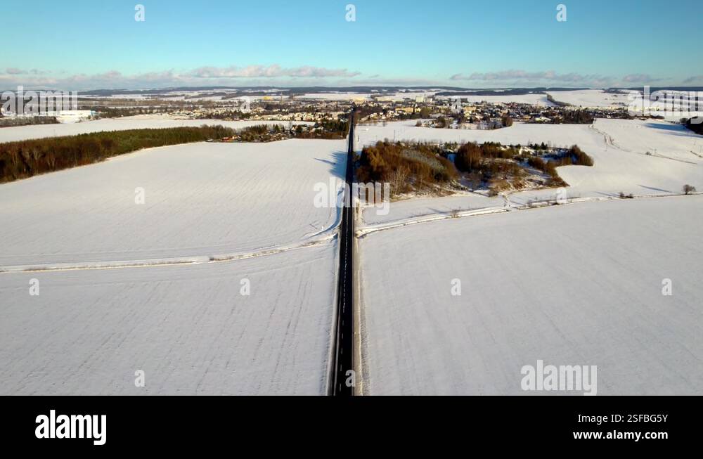 Aerial view of a straight road leading to the city as cars pass through ...