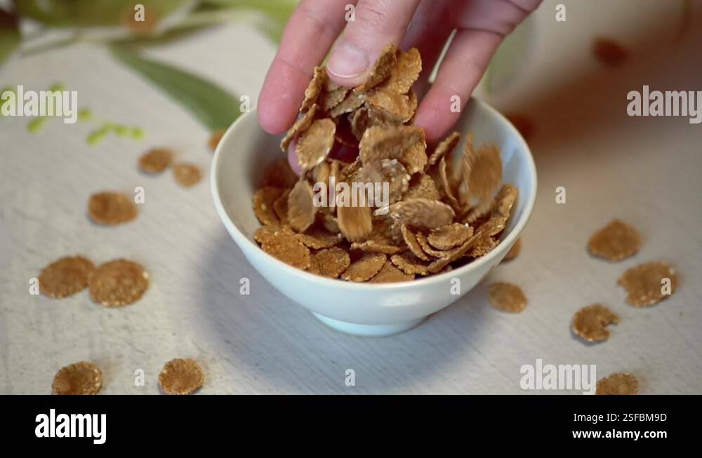 Female Hand Scatters, Pours Out, Throws Corn Flakes into a White Bowl ...