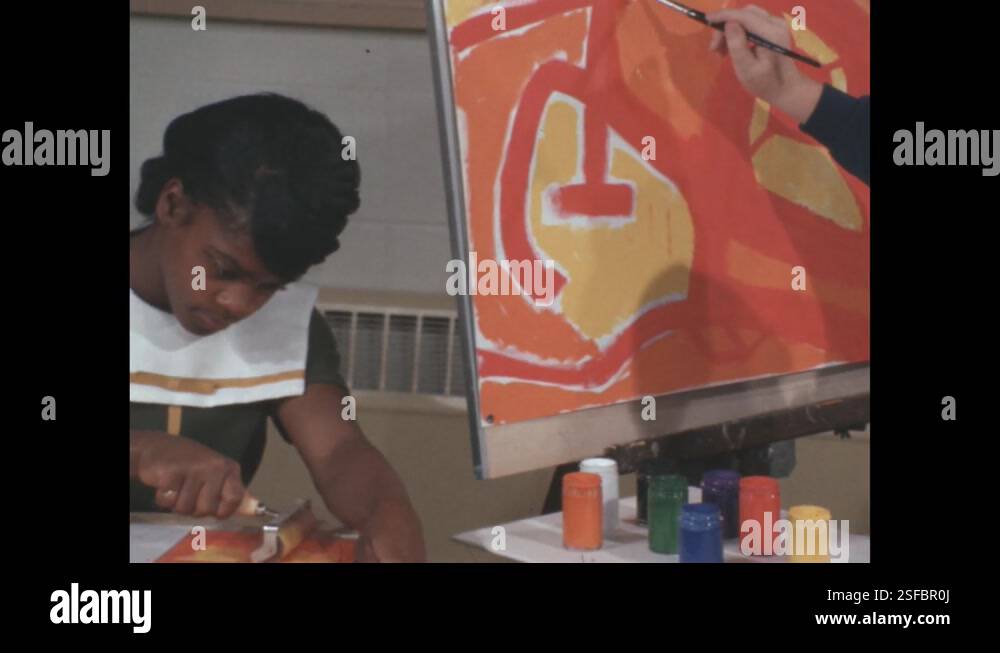 1960s: Classroom of students working on art projects: boy painting an ...