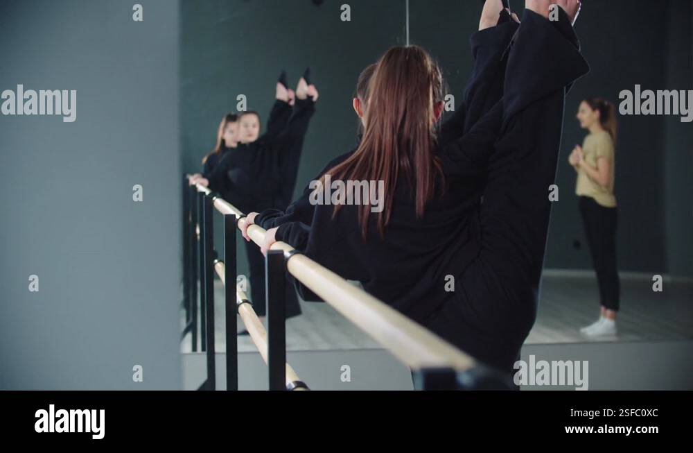 Little girl twins synchronously stretching in the studio and their ...