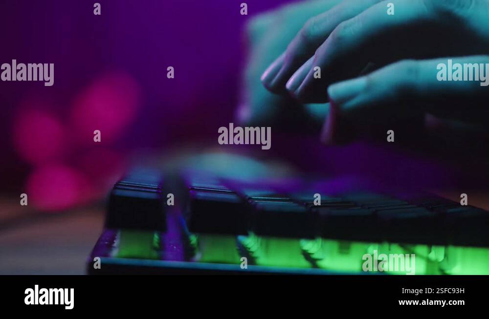 Gamer typing on backlight keyboard close-up, man playing video game ...