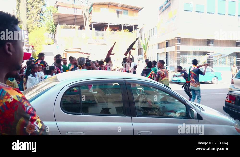 wide shot for people singing and clapping in the street in celebration ...