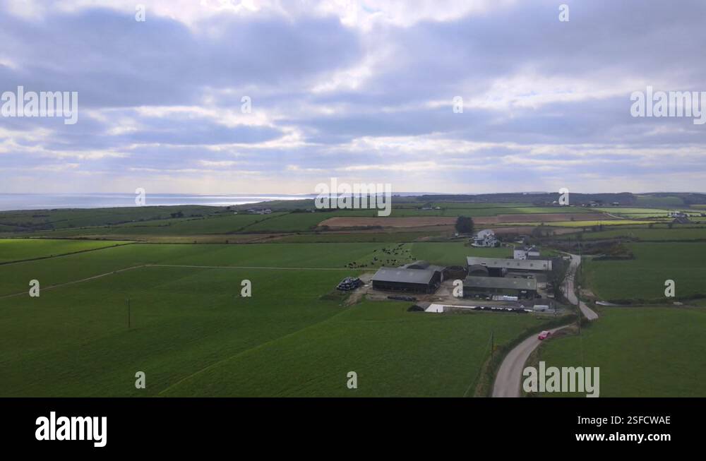 An aerial flight towards farm buildings and road with circular turn ...