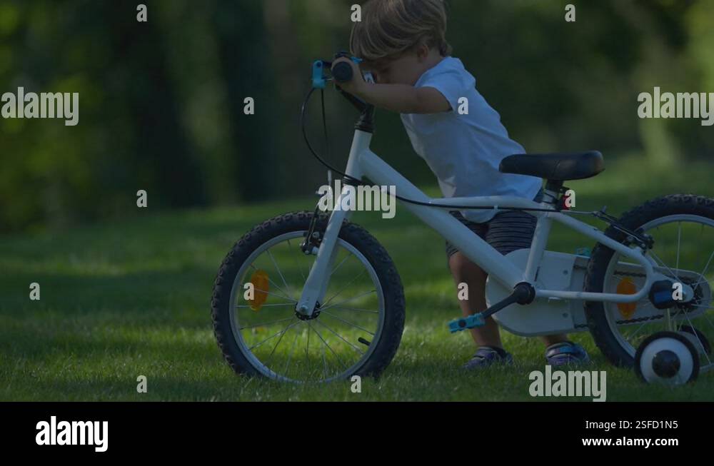 Kid carrying bicycle outside small boy carries bike wearing helmet ...