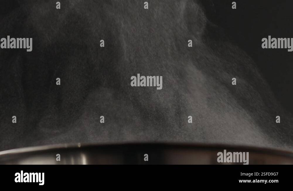 Slow motion steam rising from boiling water in pot over black ...