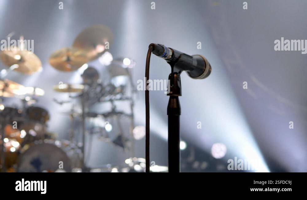 Camera pulls focus from the singer's microphone on stage to a drum kit ...