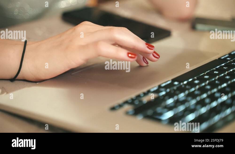 Woman fingers clicking touch pad of laptop computer, blurred backlit ...