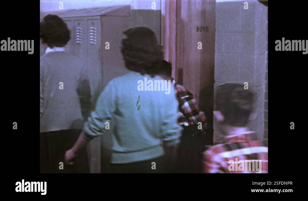 1950s: boy in doorway of restroom watches as students walk by in single ...