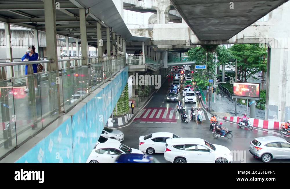 People walking on the skywalk above Traffic through busy intersections ...