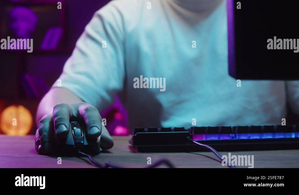 Gamer typing on backlight keyboard close-up, man playing video game ...