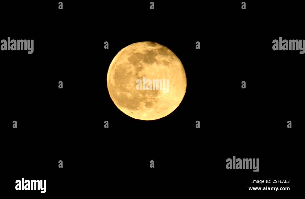 Full Moon with thin clouds in front in the dark February winter night ...