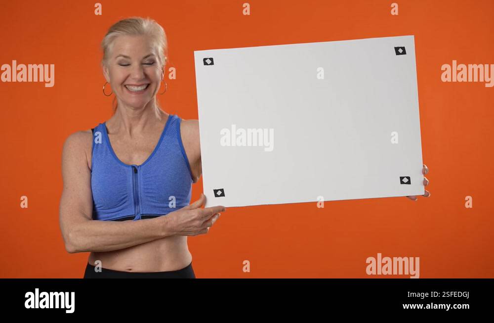 Mature strong sporty athletic fitness woman hold white blank sign board ...