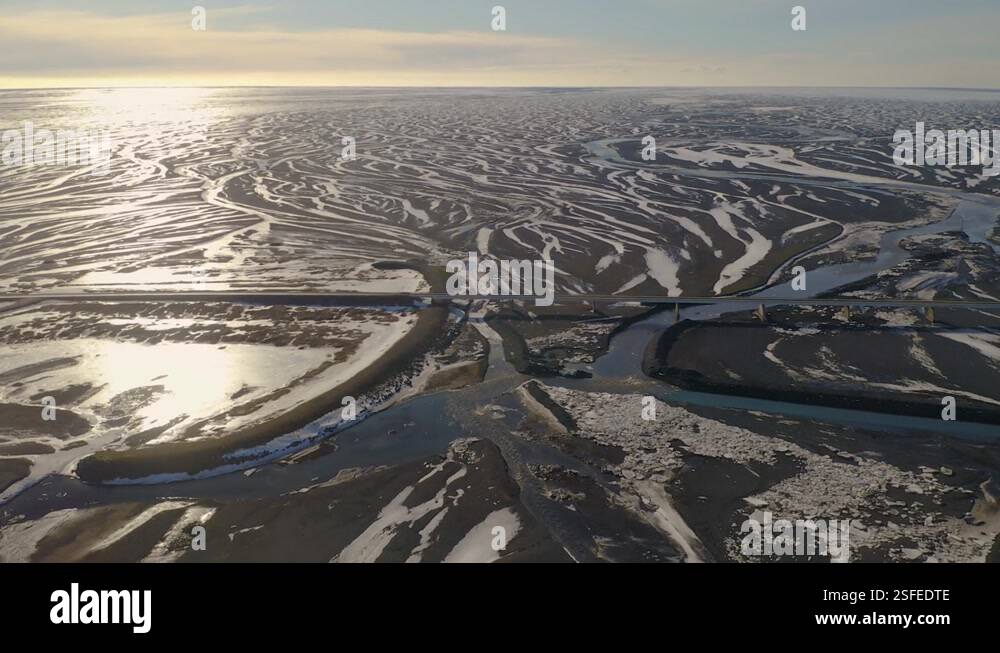 Aerial approaching shot of bridge over large river braids and river ...