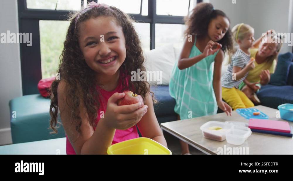 Video of happy biracial girl sitting with friends at school common room ...