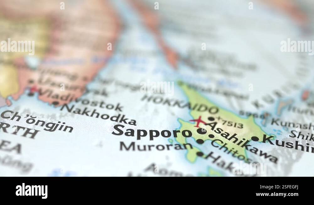 Location Sapporo in Japan, man push pin on travel map, marker close-up ...