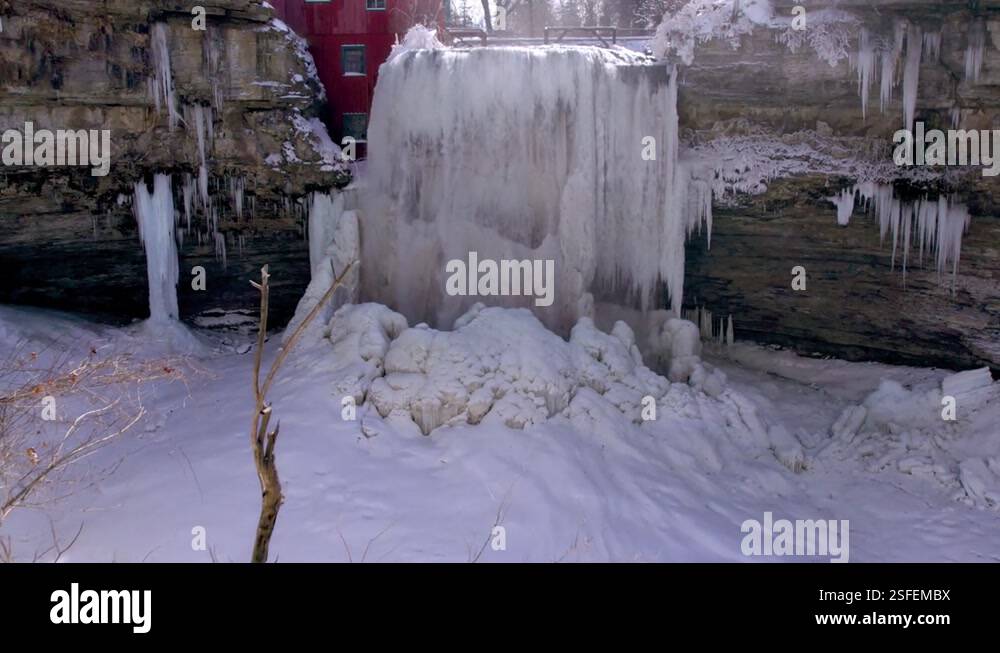 Scenic Frozen Waterfall Gorge Fly over Snow in Winter with Sawmill and ...