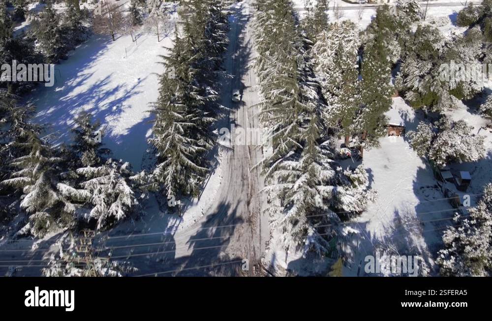 Overview over snow covered road through the small village community in ...