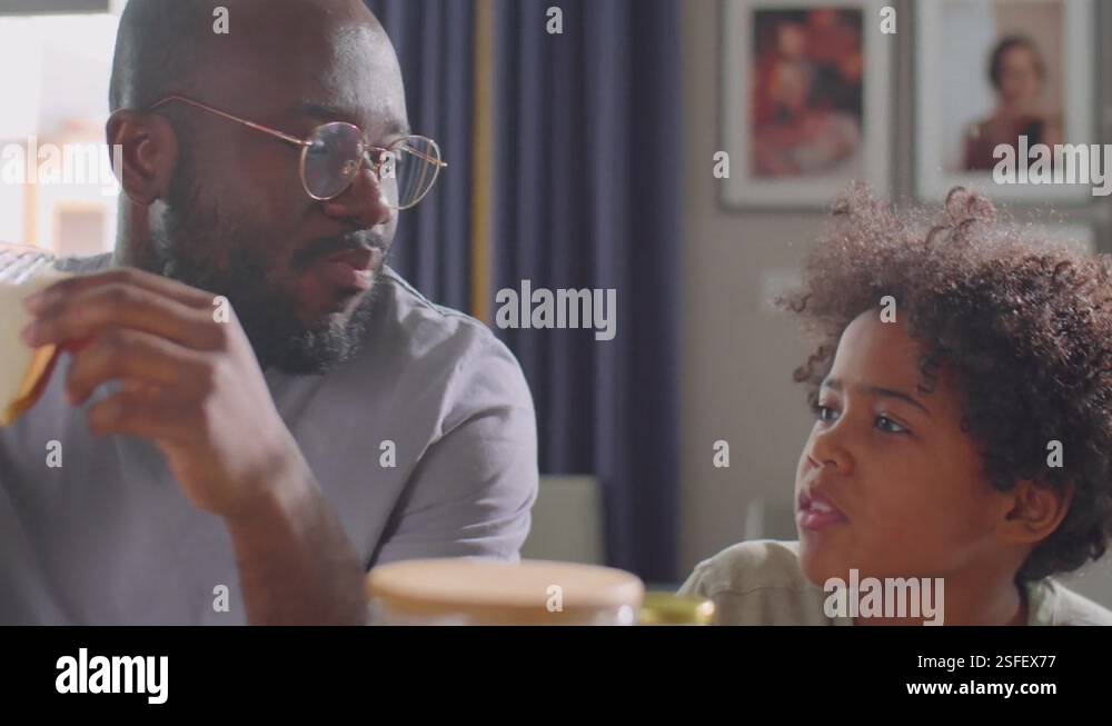 African American Dad and Little Son Eating Breakfast and Speaking Stock ...
