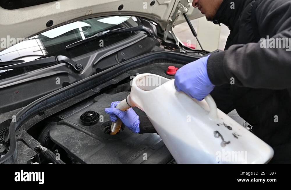 Pouring fresh mew oil into vehicle engine, slow motion push out view ...