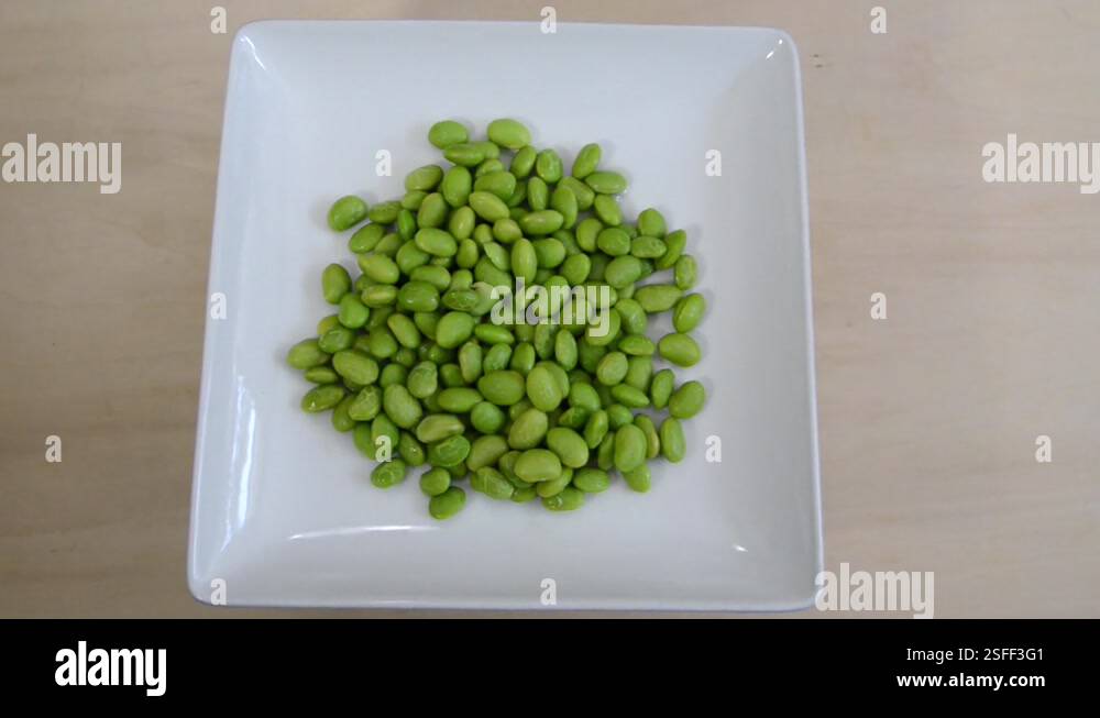 HD video zooming in on a square plate of shelled Edamame Stock Video ...