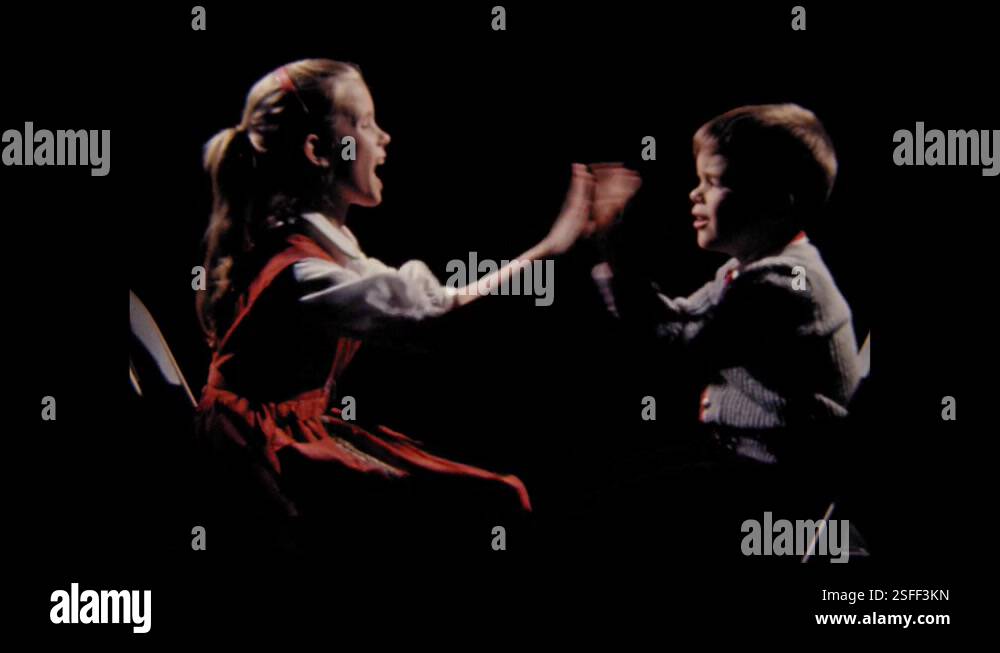 1960s: Children playing pat-a-cake. Kids slapping hands together ...