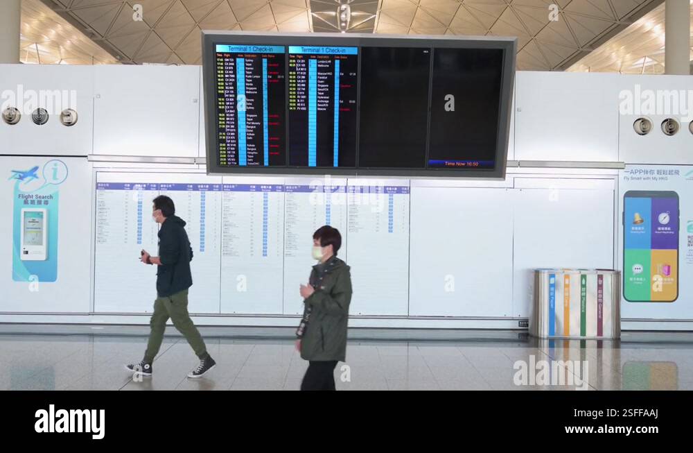 A passenger walks past a screen that signals where airline check-in ...