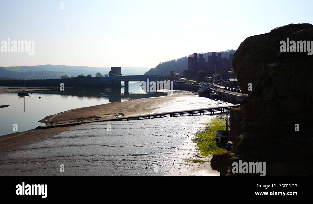 Overlooking Conwy castle low tide shimmering sandy seaside waterfront ...