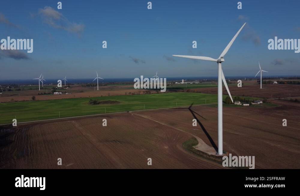 Wind Turbine Spinning Right Casting Shadow with a Field of Turbines in ...